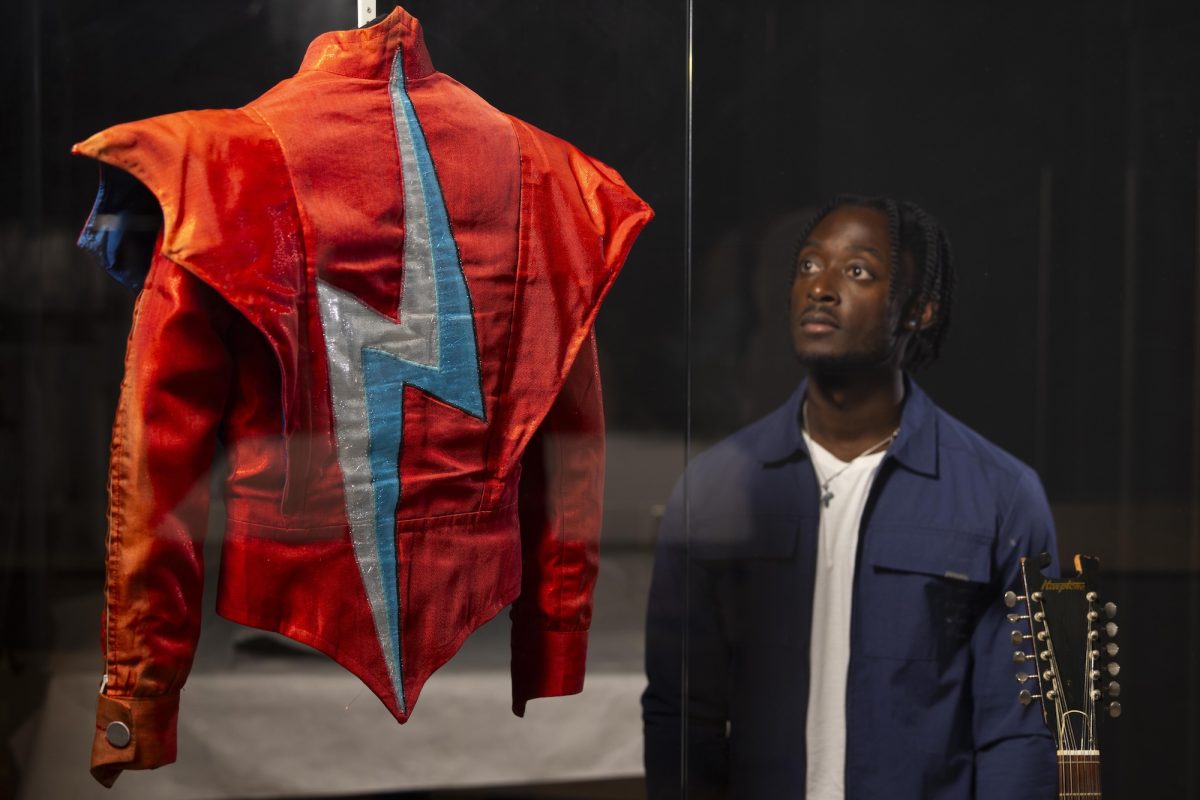 A visitor looks at the Aladdin Sane jacket designed by Freddie Burretti ...