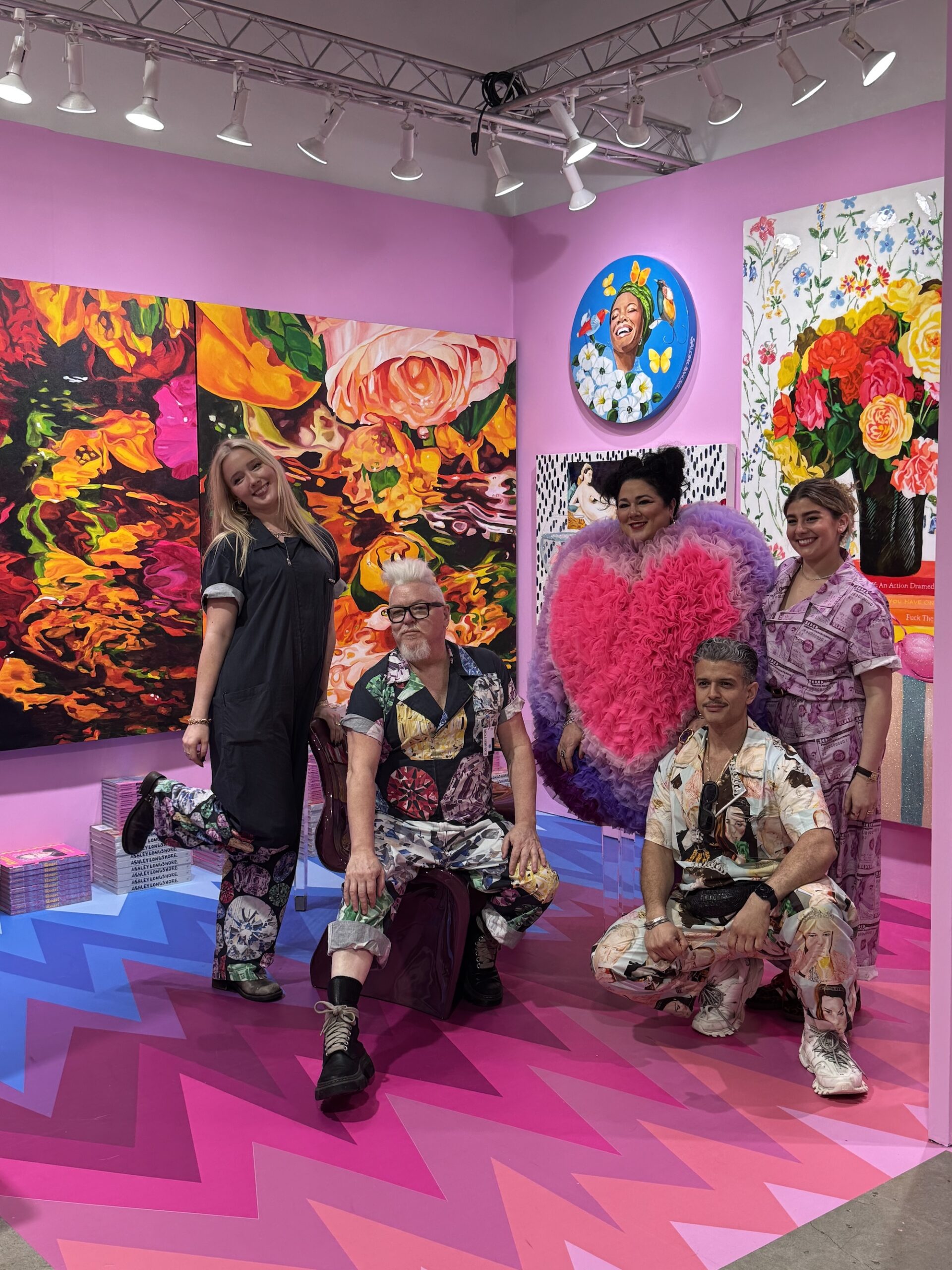 Ashley Longshore poses for a photo with her team amidst her booth ...